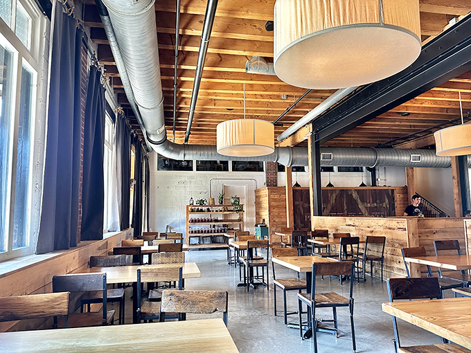 Exposed wooden beams, drum pendant lights, and concrete floors create an atmosphere where rustic charm meets urban sophistication.