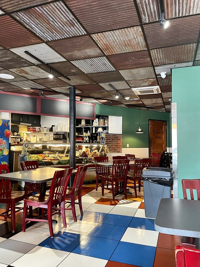 Industrial chic meets pizzeria comfort with that patchwork metal ceiling. The red chairs and checkerboard floor create the perfect backdrop for serious pizza contemplation.