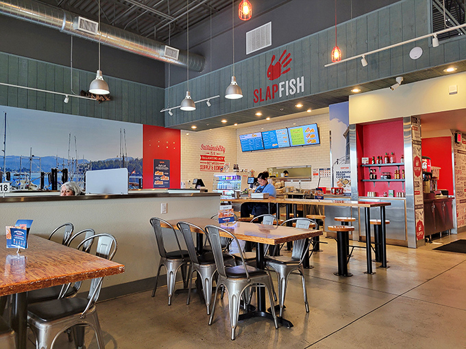 Industrial chic meets coastal cool in this airy interior where metal, wood, and splashes of red create the perfect backdrop for seafood indulgence.