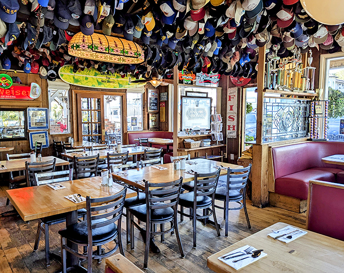 A vintage turquoise truck parked beside wine barrels under golden sail shades&mdash;this isn't just restaurant decor, it's a California coastal vibe manifested.