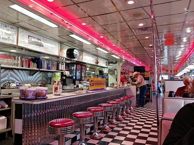 The quintessential diner experience awaits at the counter &ndash; red vinyl stools, checkered floors, and neon lights that make everyone look like they're having the time of their life.