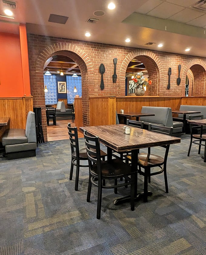 Exposed brick arches frame cozy dining nooks while oversized utensil art makes a not-so-subtle hint: serious eating happens here, and you're about to join the club.