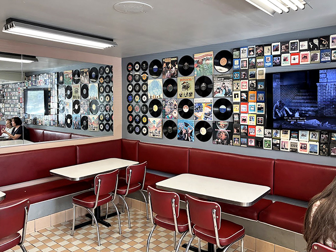 Vinyl records transform ordinary walls into a musical time machine, while classic red booths invite you to slide in and stay for "just one more coffee."