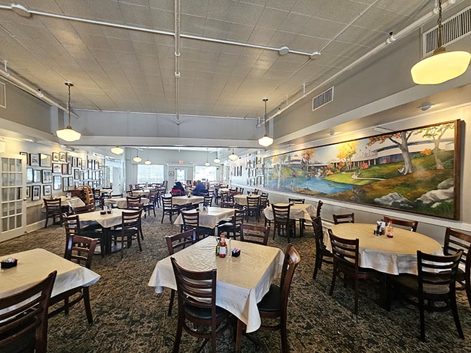 White tablecloths and wooden chairs create the perfect canvas for Southern culinary artistry, while the pastoral mural whispers stories of Georgia's countryside heritage.