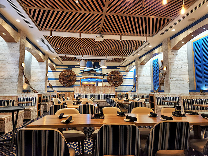 Nautical elegance meets coastal comfort under a striking wooden ceiling that mimics the hull of a ship turned upside down.