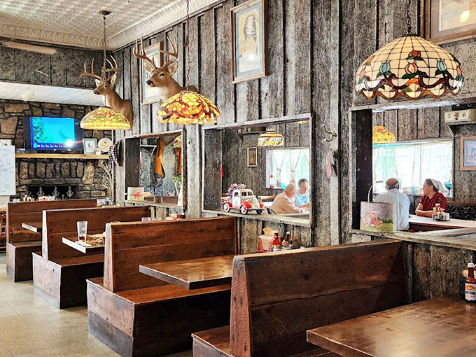 Step inside to a world where stained glass lamps cast warm light over wooden booths, and mounted deer heads silently approve of your menu choices.