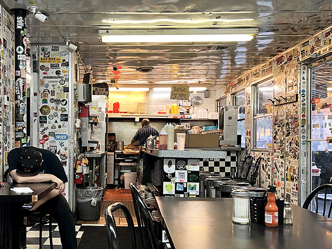 Inside this stainless steel sanctuary, every inch tells a story &ndash; walls plastered with stickers and memorabilia chronicle decades of late-night conversations and early morning revelations.