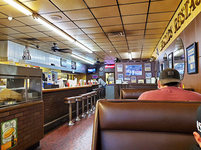 Classic diner perfection awaits inside—vinyl booths worn to that perfect patina, counter seating for the solo burger enthusiast, and ceiling fans lazily circulating promises of deliciousness.
