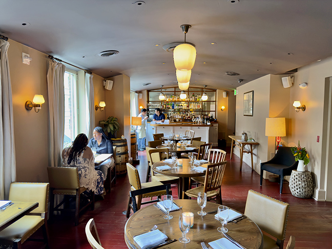 Warm lighting, wooden tables, and cream-colored chairs create that rare dining atmosphere where you feel both pampered and perfectly at home.