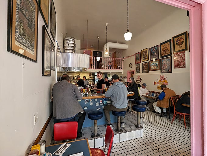 Inside, the narrow dining space feels like a time capsule where strangers become temporary breakfast companions. The black and white tiles have witnessed countless hangover cures.