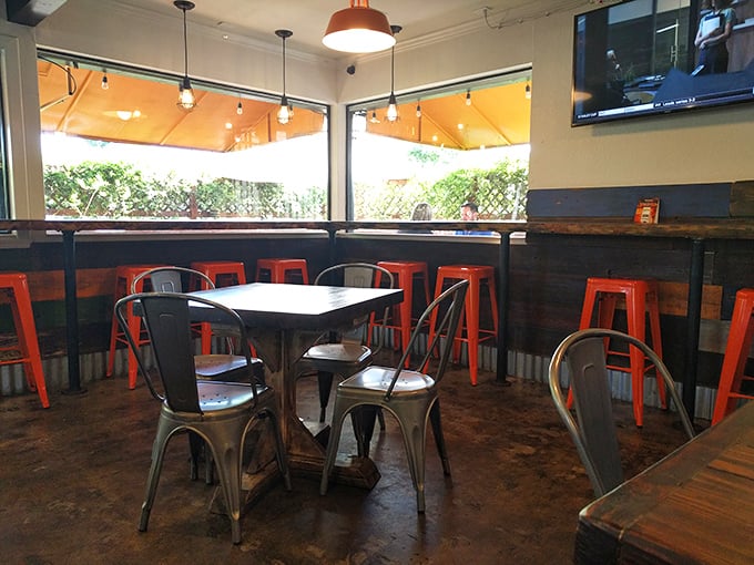Industrial-chic meets comfort in this thoughtfully designed space where bright orange stools pop against metal chairs and wooden tables&mdash;perfect for serious hot dog contemplation.