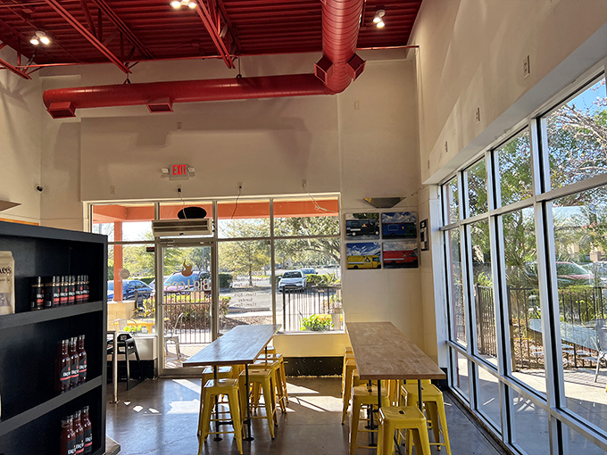 Sunshine floods through floor-to-ceiling windows, illuminating a space where yellow stools stand ready for the serious business of barbecue appreciation.