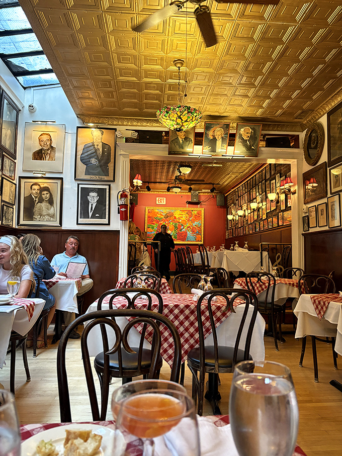Opera legends watch over diners from every wall, while the golden tin ceiling reflects warm light across red-checkered tables&mdash;dinner with a side of history.