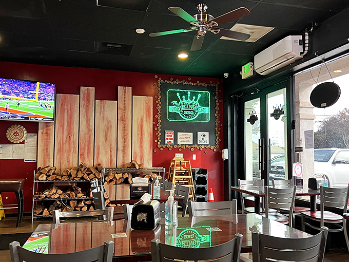 Stacked firewood isn't just decor&mdash;it's a promise of authentic smoking. The red walls and neon sign set the stage for meat magic.