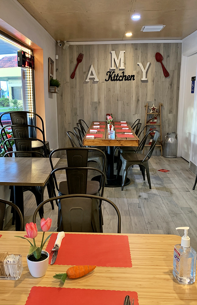 Inside, the "AMY Kitchen" wall with oversized red utensils sets the tone&mdash;serious about food, but never stuffy. Those fresh tulips are the perfect touch.