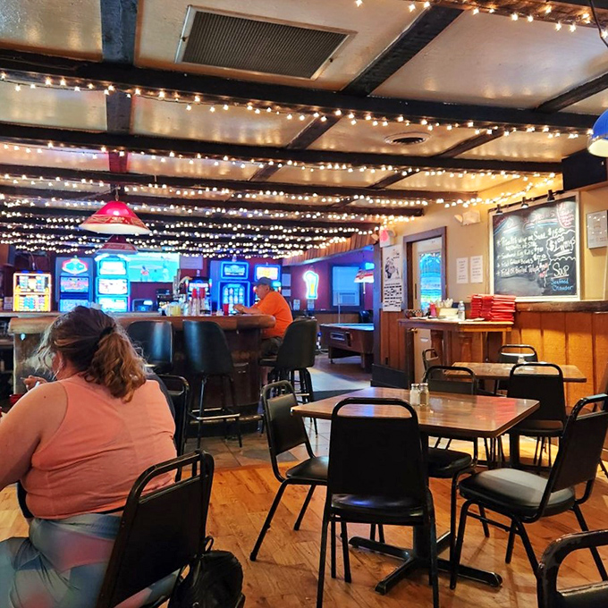 Twinkling string lights create a warm, inviting atmosphere inside. The kind of place where strangers become friends over plates of legendary fried chicken.
