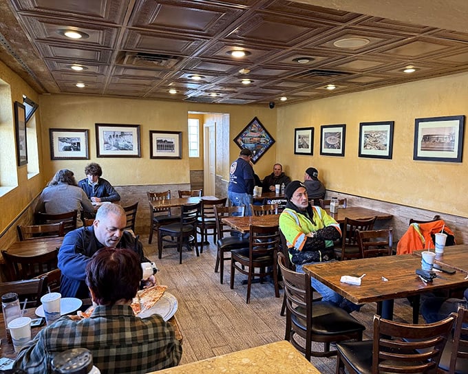 Inside, yellow walls adorned with neighborhood history create a time capsule where conversations flow as freely as the pizza sauce.