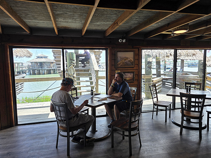 Rustic wooden beams frame million-dollar water views, proving that sometimes the best dining rooms don't need fancy chandeliers or white tablecloths.