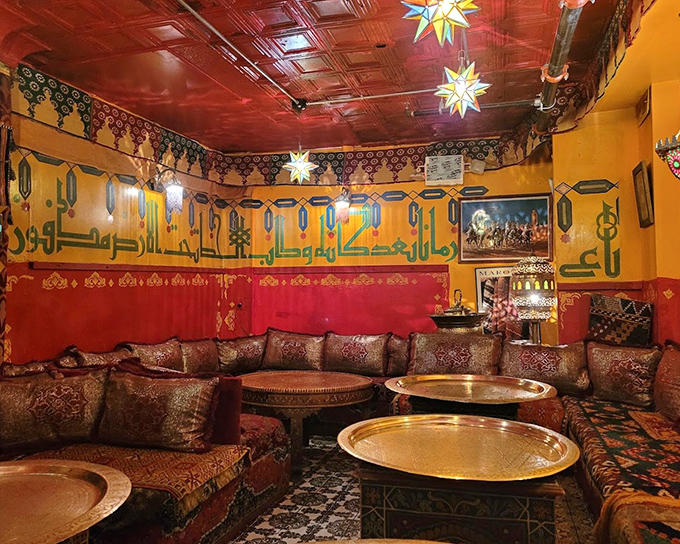 Step into a world where vibrant yellow walls meet rich red ceilings, where star-shaped lanterns cast a warm glow over low cushioned seating that invites you to linger.