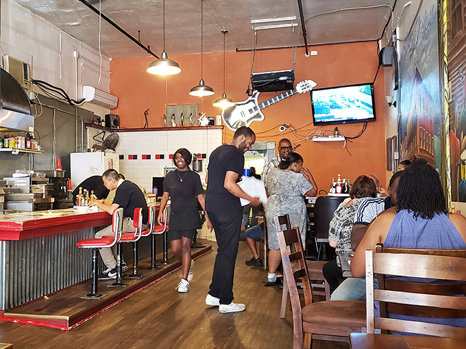 Inside, the warm orange walls and casual counter seating create that rare atmosphere where strangers become friends over plates of soul-satisfying goodness.