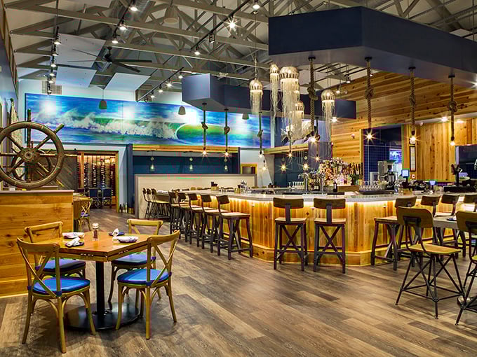 Nautical meets modern inside Hook & Barrel, where warm wood tones, jellyfish-inspired lighting, and that magnificent ship's wheel create the perfect maritime mood.