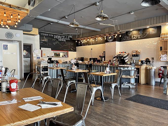 Industrial-chic meets cozy comfort with metal chairs, wooden tables, and pendant lighting creating an atmosphere that's both nostalgic and modern.