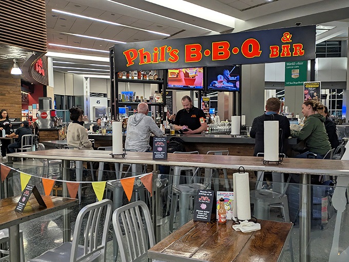 The bar area buzzes with anticipation as patrons gather for liquid courage before facing the delicious dilemma of what to order.