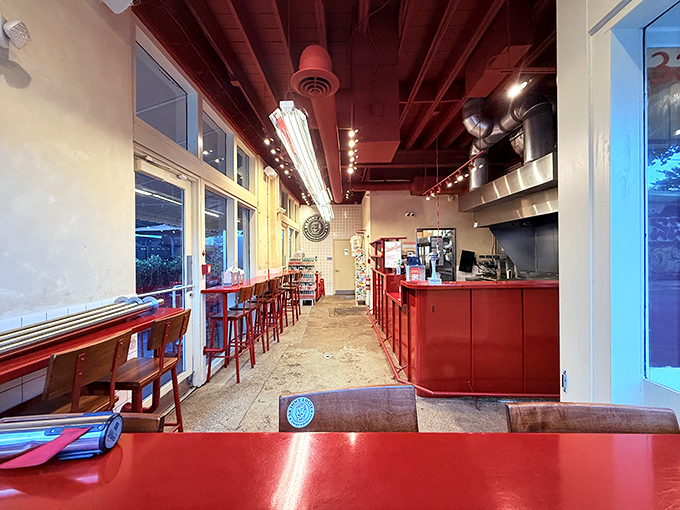 Minimalist design with maximum impact&mdash;red accents and an open kitchen where burger artistry happens before your eyes.