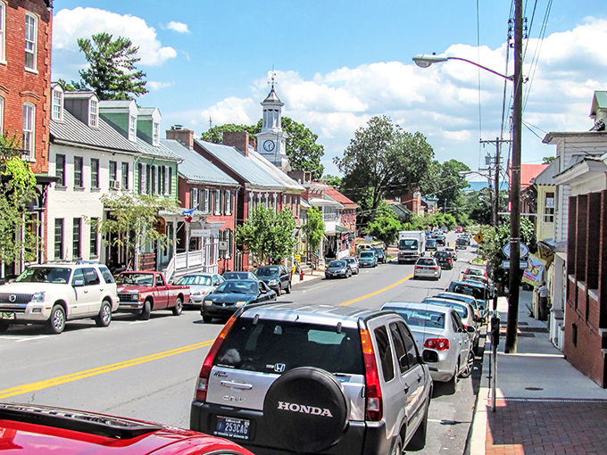 The iconic clock tower watches over Shepherdstown's main thoroughfare, where cars park along brick sidewalks that have witnessed centuries of American history.