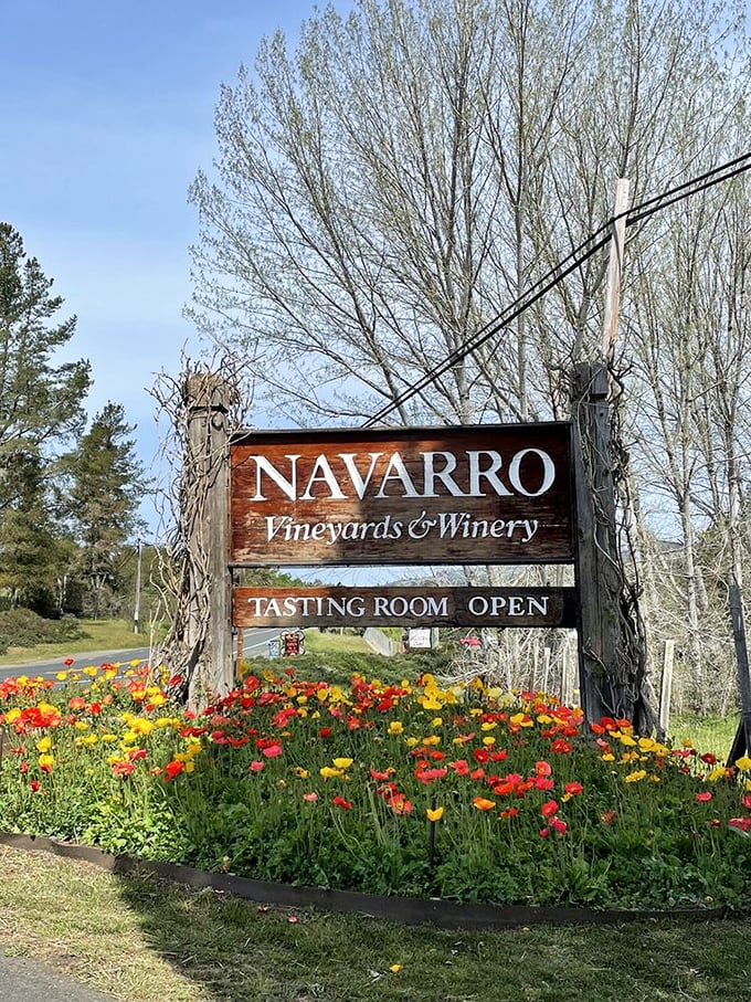 This wooden sign surrounded by wildflowers isn't just directions &ndash; it's an invitation to slow down and savor what's ahead.