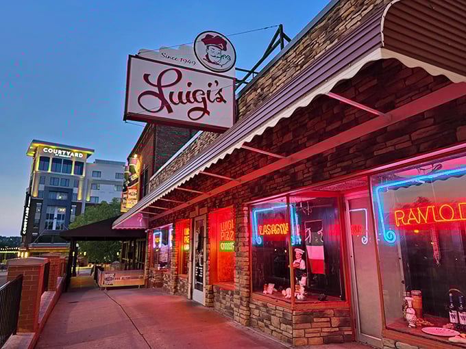 Luigi's neon-lit storefront glows like a beacon for pasta pilgrims after dark. Pizza paradise awaits inside!
