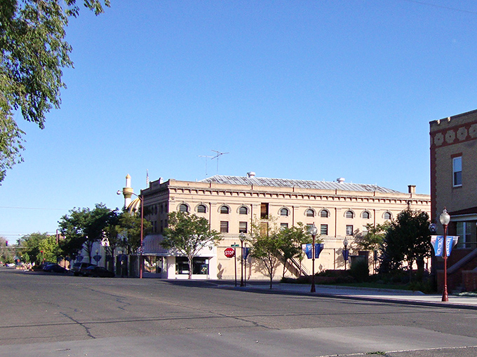 Classic American main street stretches toward distant peaks, promising affordable living with million-dollar views ahead.