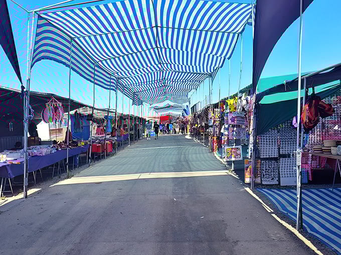Blue-striped canopies create a carnival atmosphere where deals dance under the desert sun.