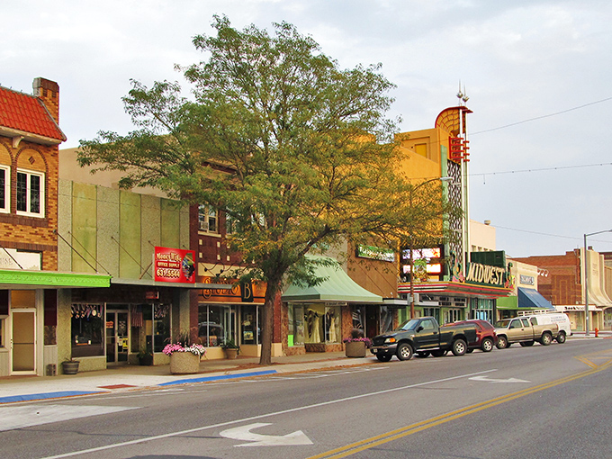Showtime in Scottsbluff! The MIDWEST theater's marquee winks at passersby like a Technicolor dream amid the prairie's brick-and-mortar symphony.