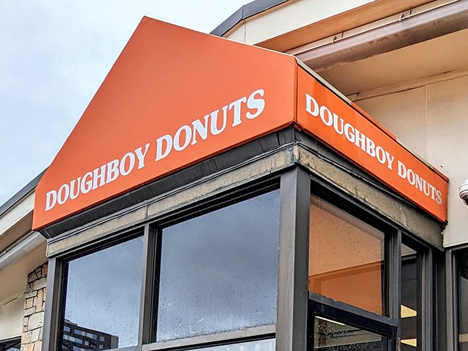 That distinctive orange Doughboy Donuts sign promises sweet salvation inside &ndash; no passport required for this flavor journey.