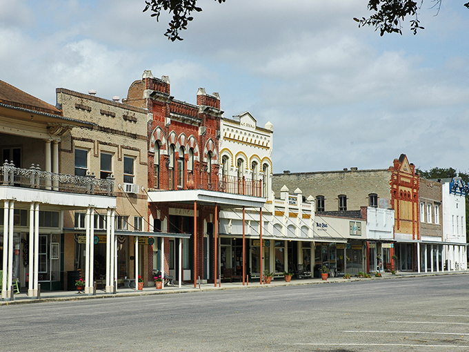The impressive facades of Goliad's main street buildings stand as proud sentinels of Texas history, their detailed stonework catching the afternoon light.