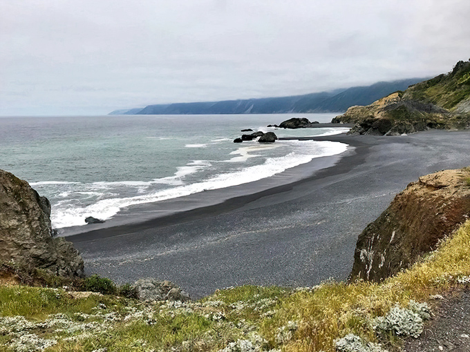 Nature's contrast party! Dark sands meet turquoise waters at this hidden gem near Whitethorn.