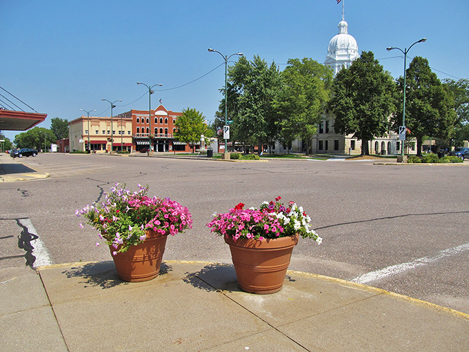 Classic courthouse architecture anchors a town square where community spirit blooms as beautifully as summer flowers.