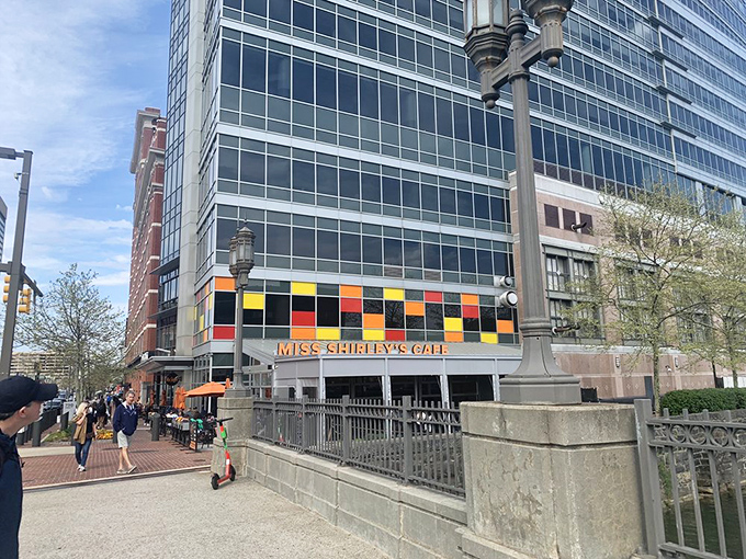 The vibrant exterior of Miss Shirley's Cafe stands out among Baltimore's modern buildings like a delicious rainbow.