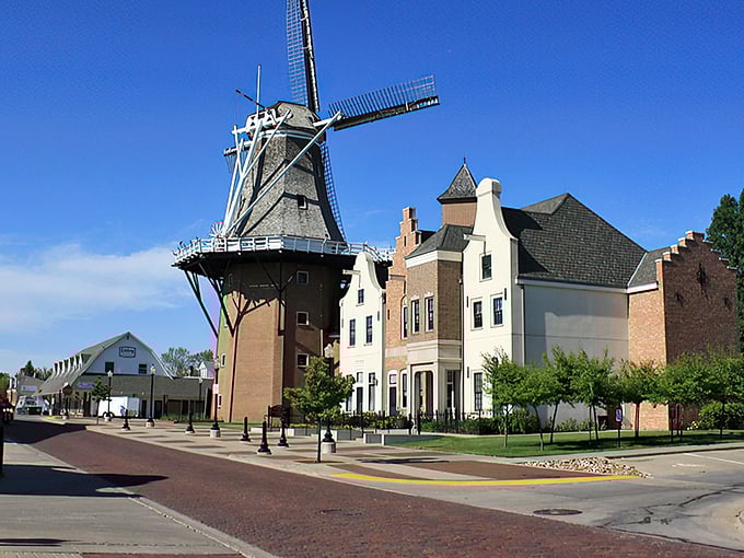 Pella's iconic windmill stands tall against the blue sky, surrounded by buildings that transport visitors straight to the Netherlands.