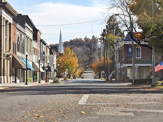 Fall leaves carpet this quiet street, where church spires point toward both heaven and sensible housing costs.