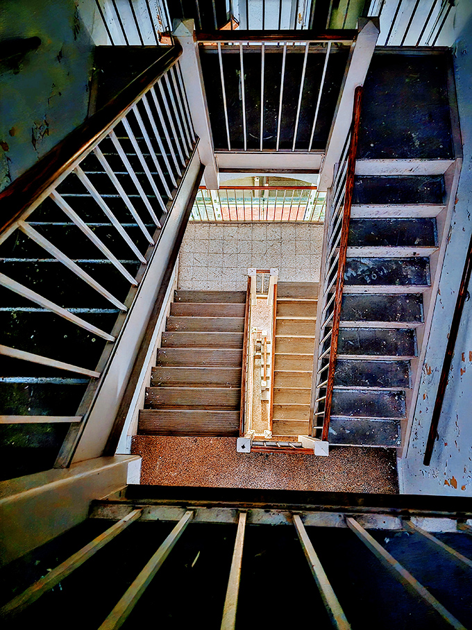Looking down this stairwell feels like peering into a portal to the past. Each step creaks with secrets of those who once walked these halls.
