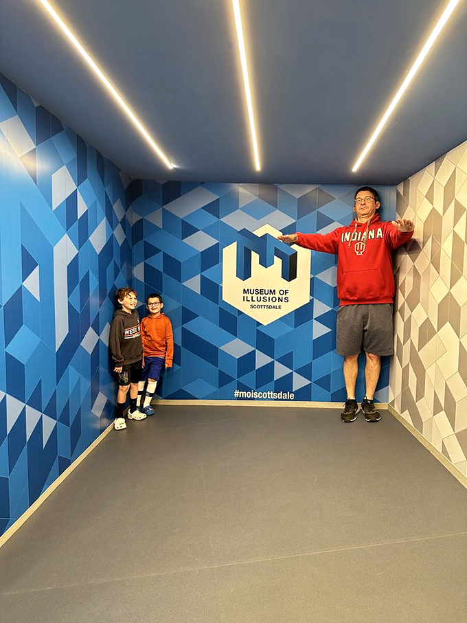 Size matters? Not here! The Ames Room creates an optical illusion where people appear to shrink or grow as they move across the space.