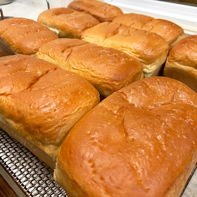 Golden loaves of homemade bread cooling on racks&mdash;the kind that makes your supermarket bread hang its head in shame.