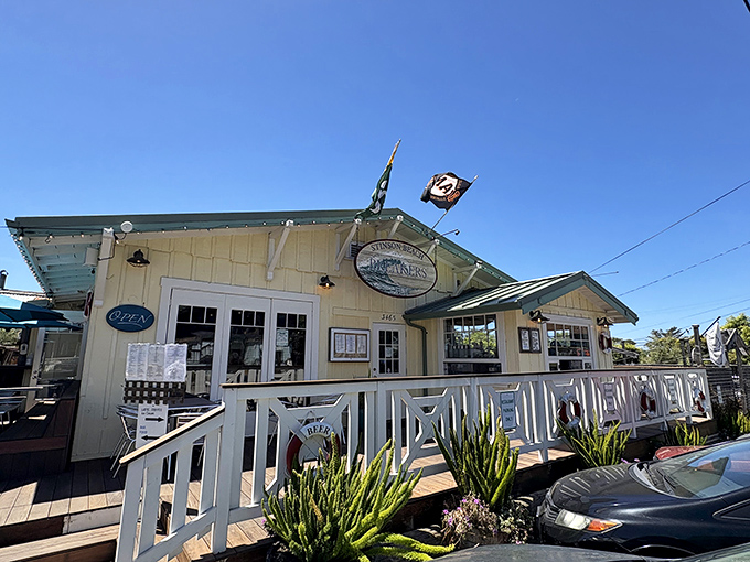 Breakers Café stands as a cheerful sentinel of sustenance, its white railings and sunny yellow exterior promising comfort food with ocean views.