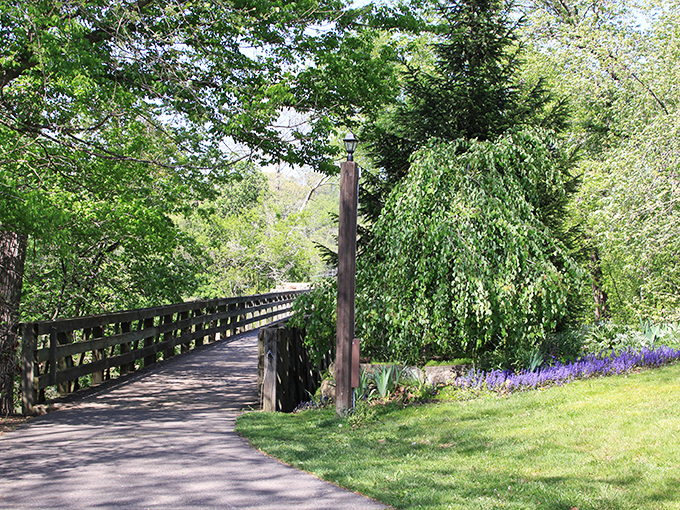 This tranquil pathway through Coshocton's greenery isn't just a bridge; it's a portal to the kind of serenity our notification-filled lives desperately need.