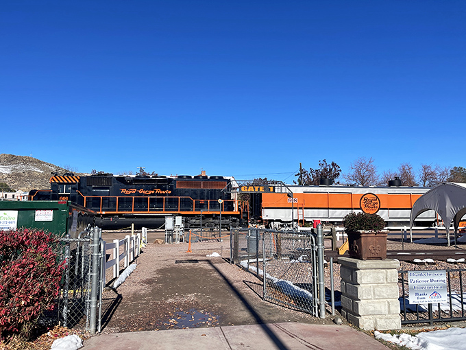 All aboard! The distinctive orange and black locomotive waits patiently for passengers, like a friendly giant ready for its next adventure.
