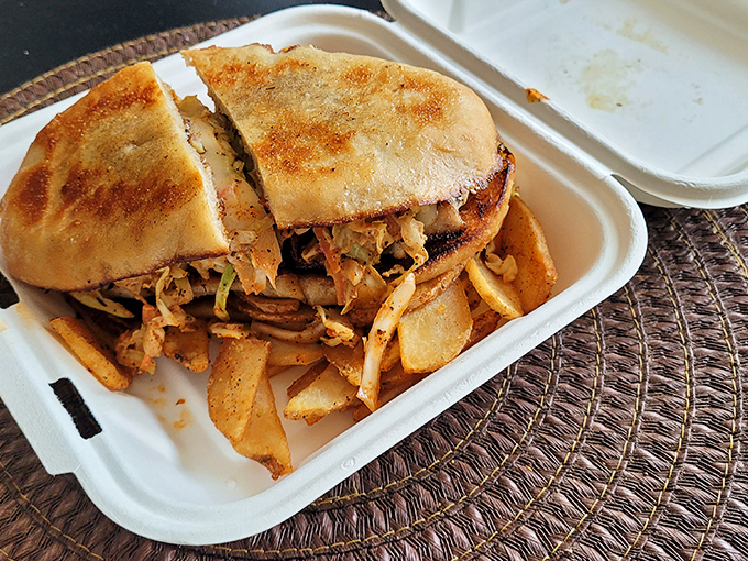 This isn't just a sandwich; it's architecture. Golden-toasted bread barely containing a treasure of seasoned fish and crispy fries on the side.