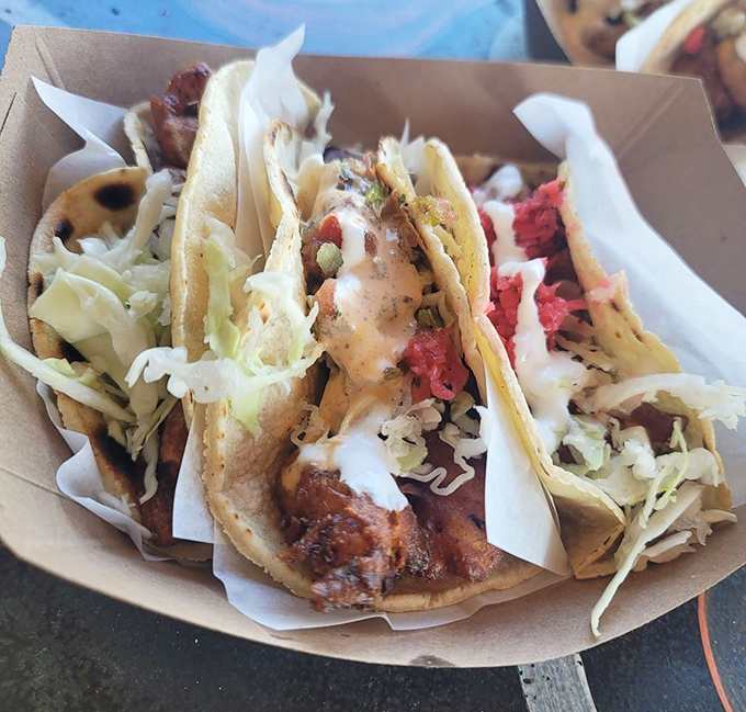 Behold the holy trinity: perfectly battered fish, fresh cabbage, and house sauces nestled in corn tortillas. Poetry you can eat.