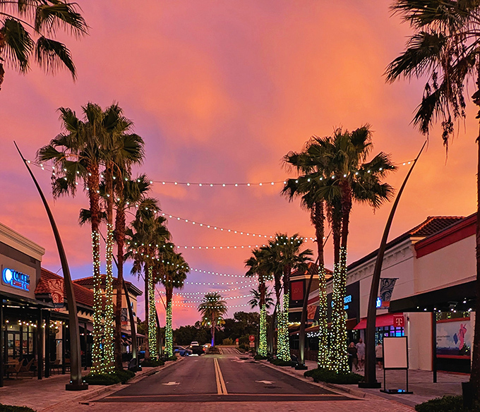 Twilight transforms ordinary walkways into magical passages, with palm trees wrapped in twinkling lights creating a sunset shopping experience worth lingering for.